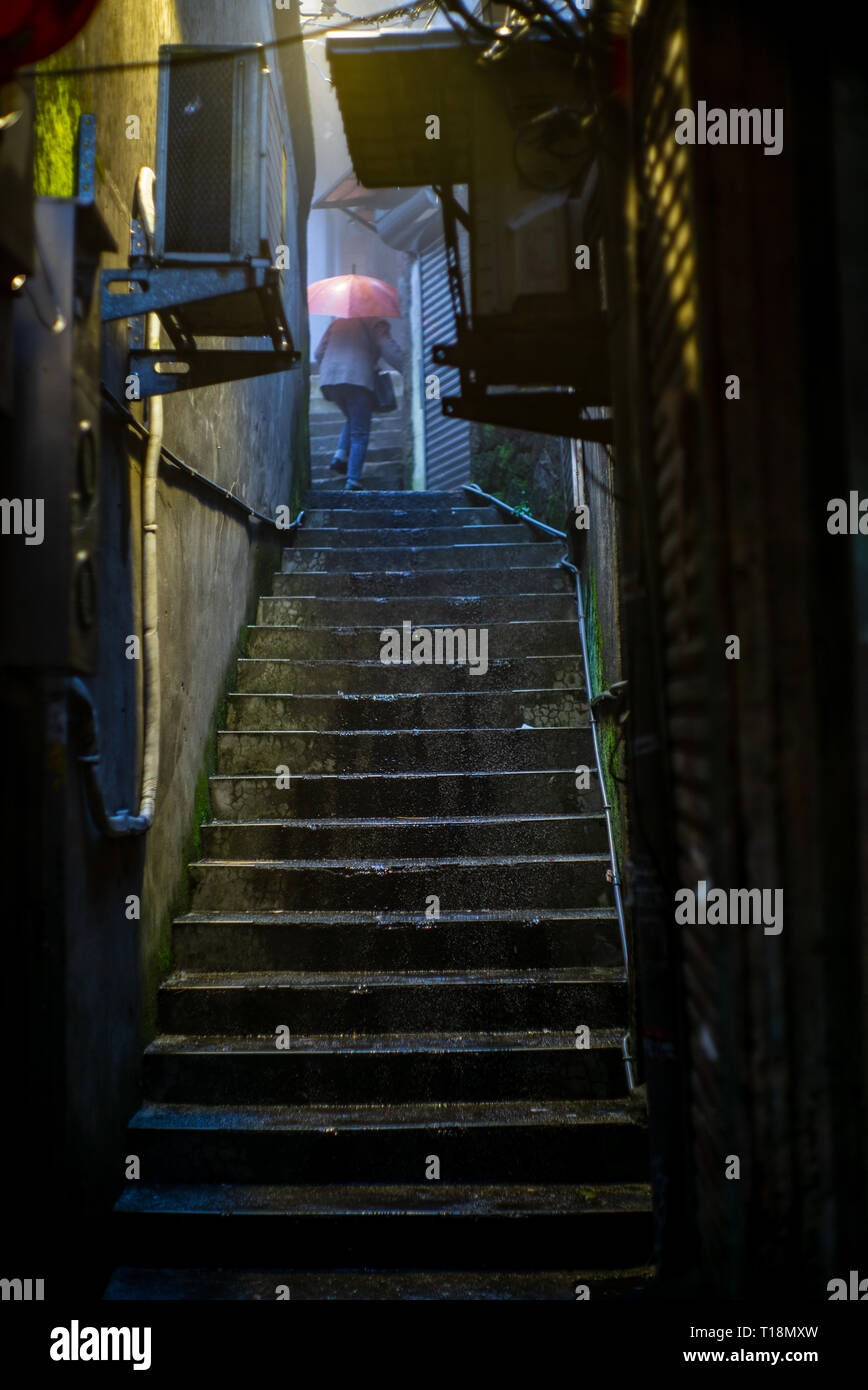 An old Chinese lady with an umbrella in a mysterious back alley and ...