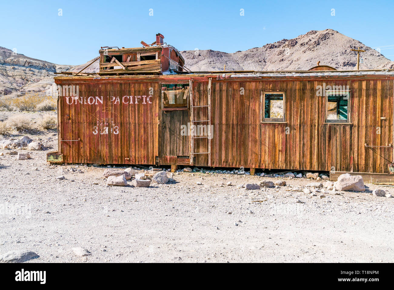 An abandoned, wheel-less Union Pacific caboose decaying in the Mojave Desert ghost town of ...