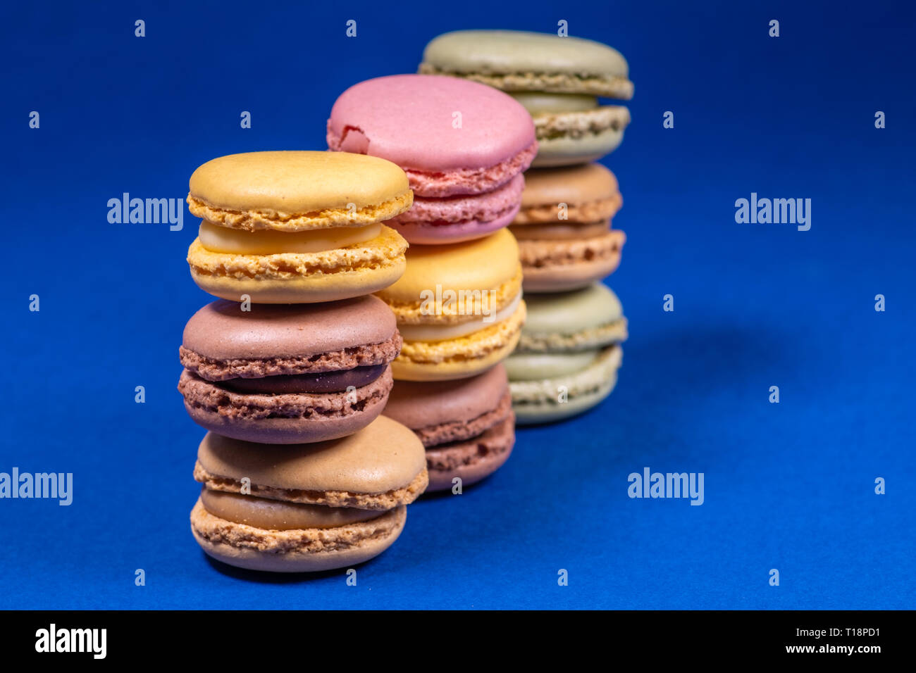 Colorful french macarons isolated on blue background. Pastel colors ...