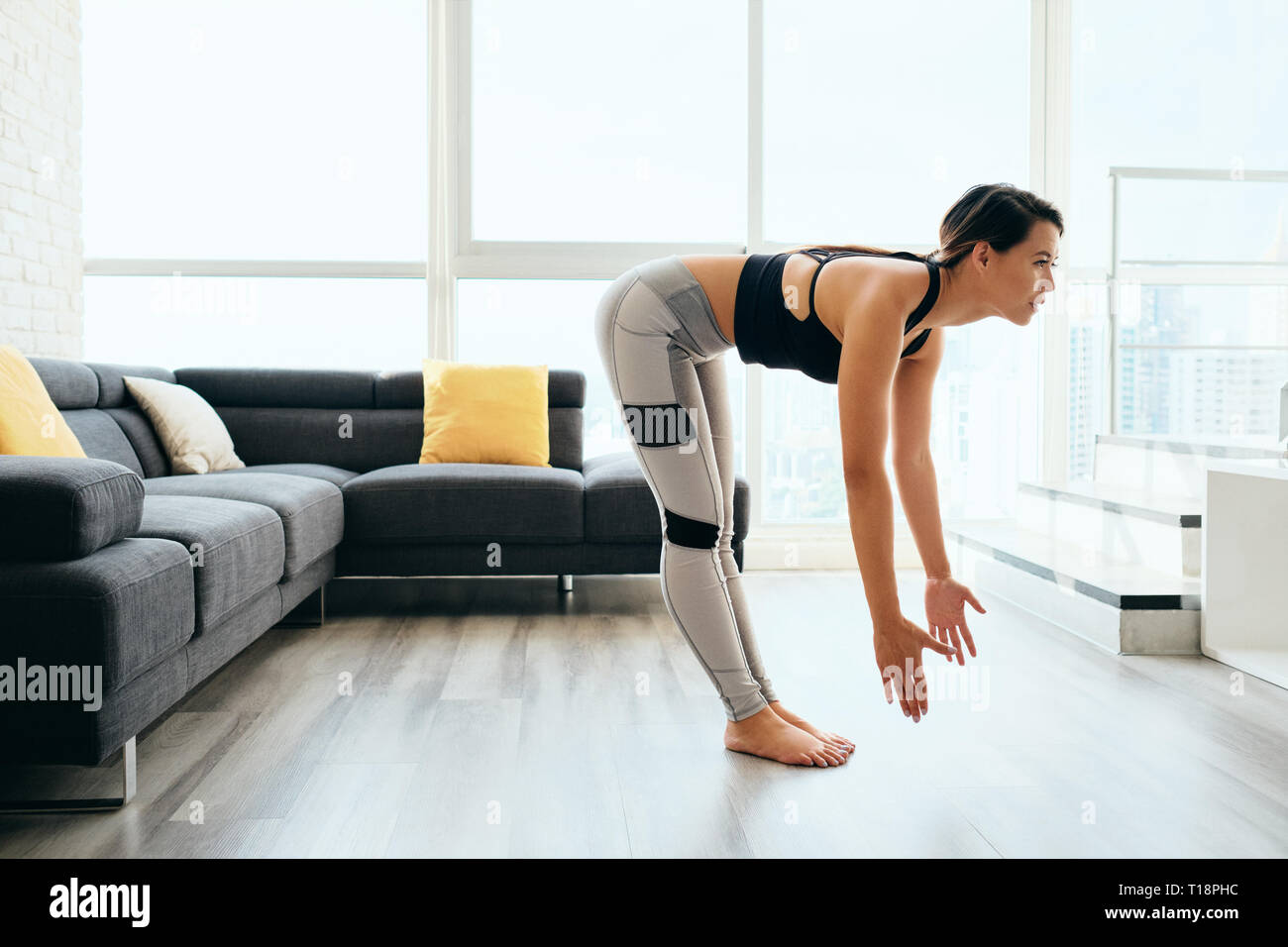 Woman Practicing Yoga At Home Doing Sun Salutation Routine Stock Photo ...