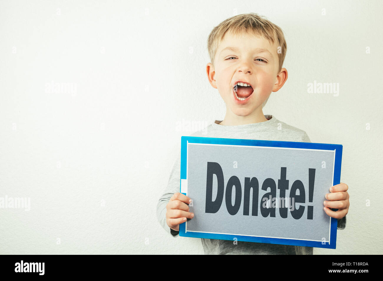 Donation concept - boy holding board with Donate on it Stock Photo - Alamy