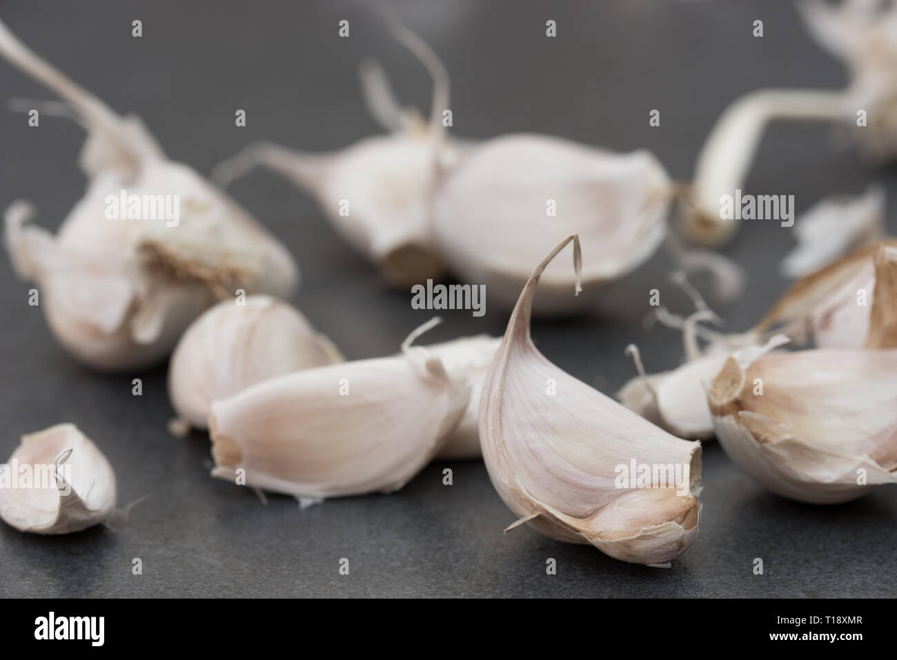 unpeeled garlic cloves macro on gray table Stock Photo - Alamy
