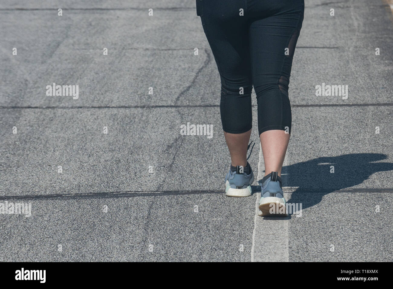 Legs of a runner jogging on asphalt road in sport shoes Stock Photo - Alamy
