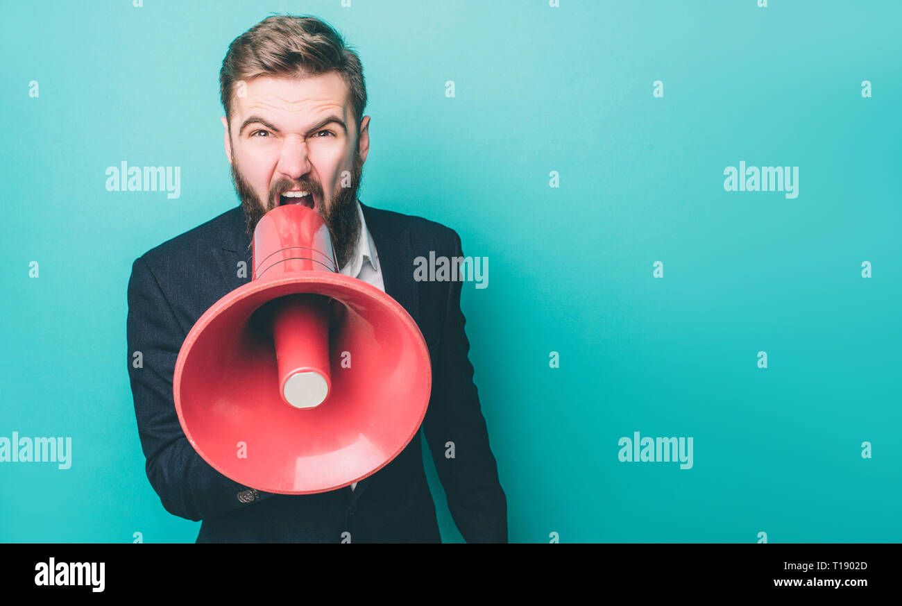 Serious guy is screaming and yelling using the loudspeaker. He is doing ...