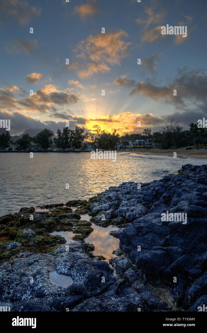 Sunset clouds reflect from a small pool of water in some volcanic rocks ...