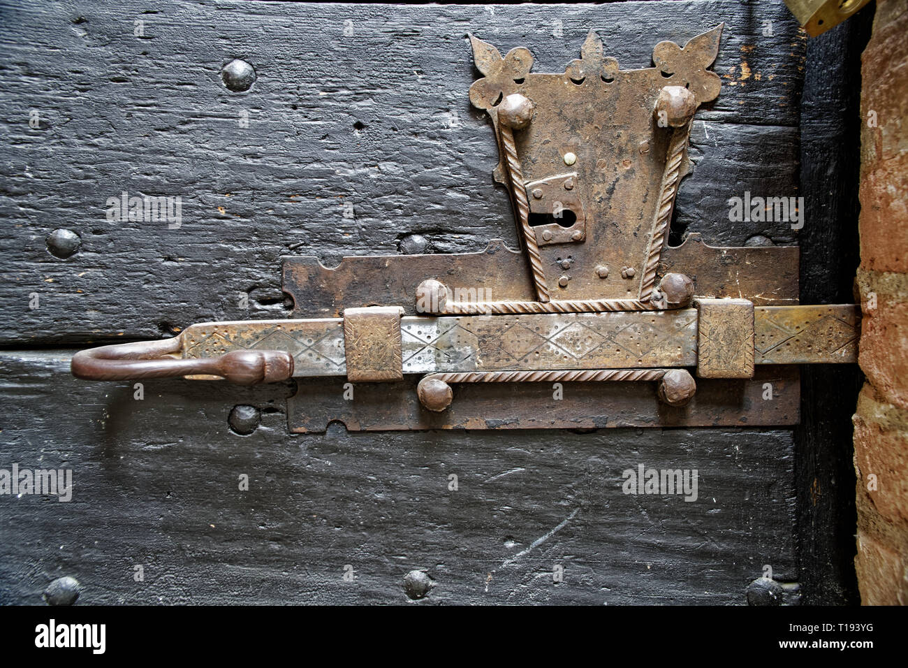 Old wooden door with metal knob and rusty medieval bolt Stock Photo - Alamy