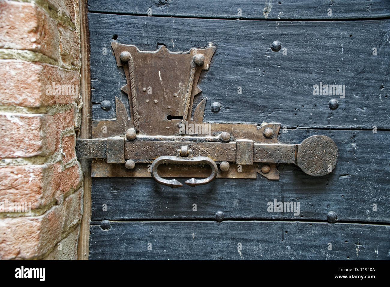 Old wooden door with metal knob and rusty medieval bolt Stock Photo - Alamy