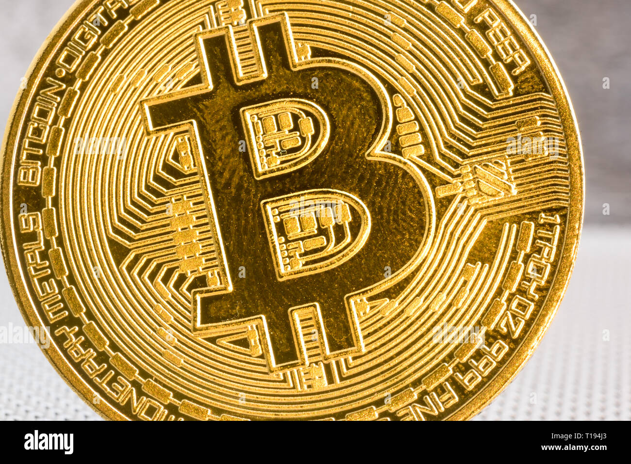 Close up macro front view of single golden bit coin on silver metallic background Stock Photo ...