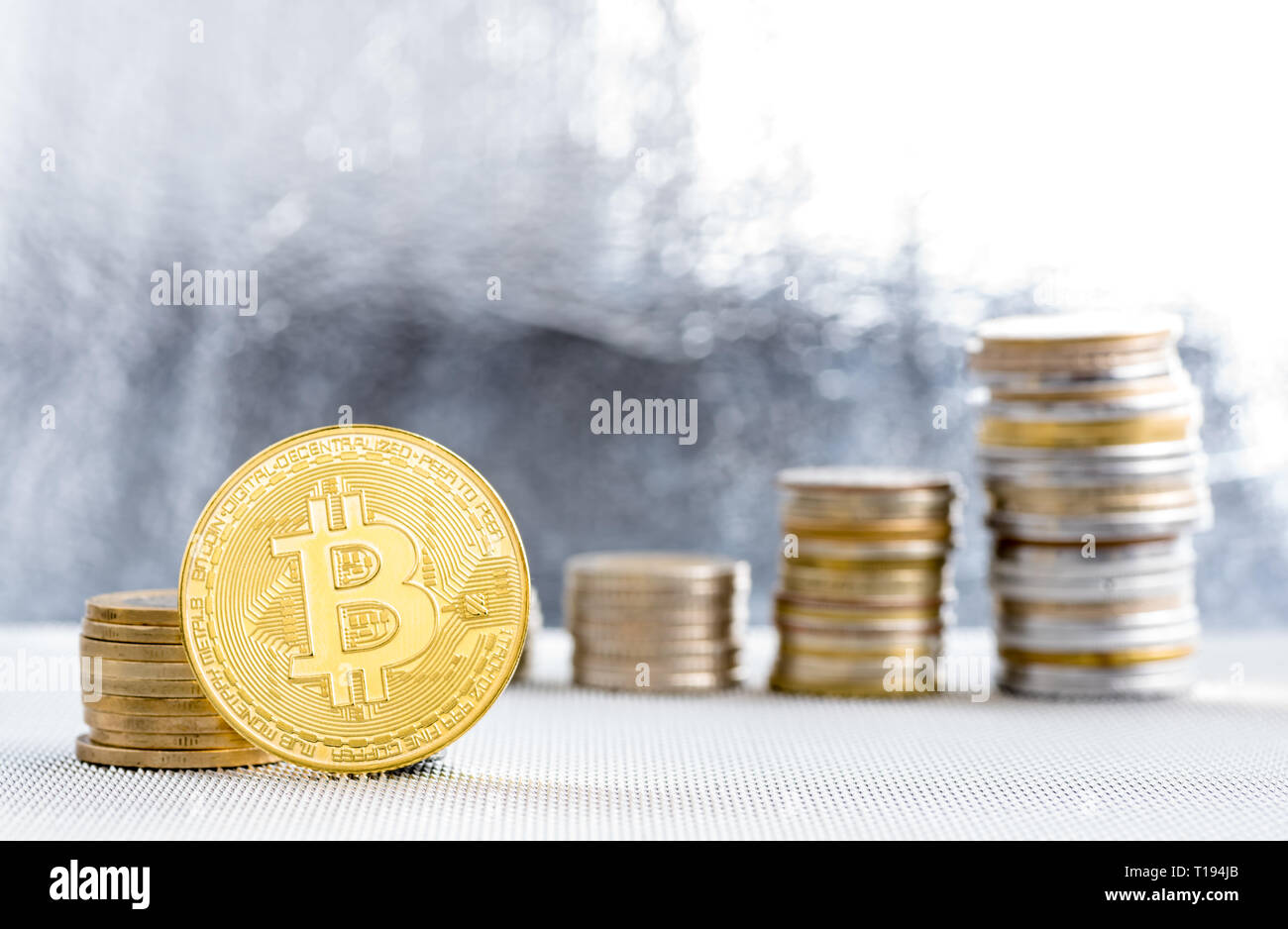 Front view of single golden bit coin with money stack on silver ...