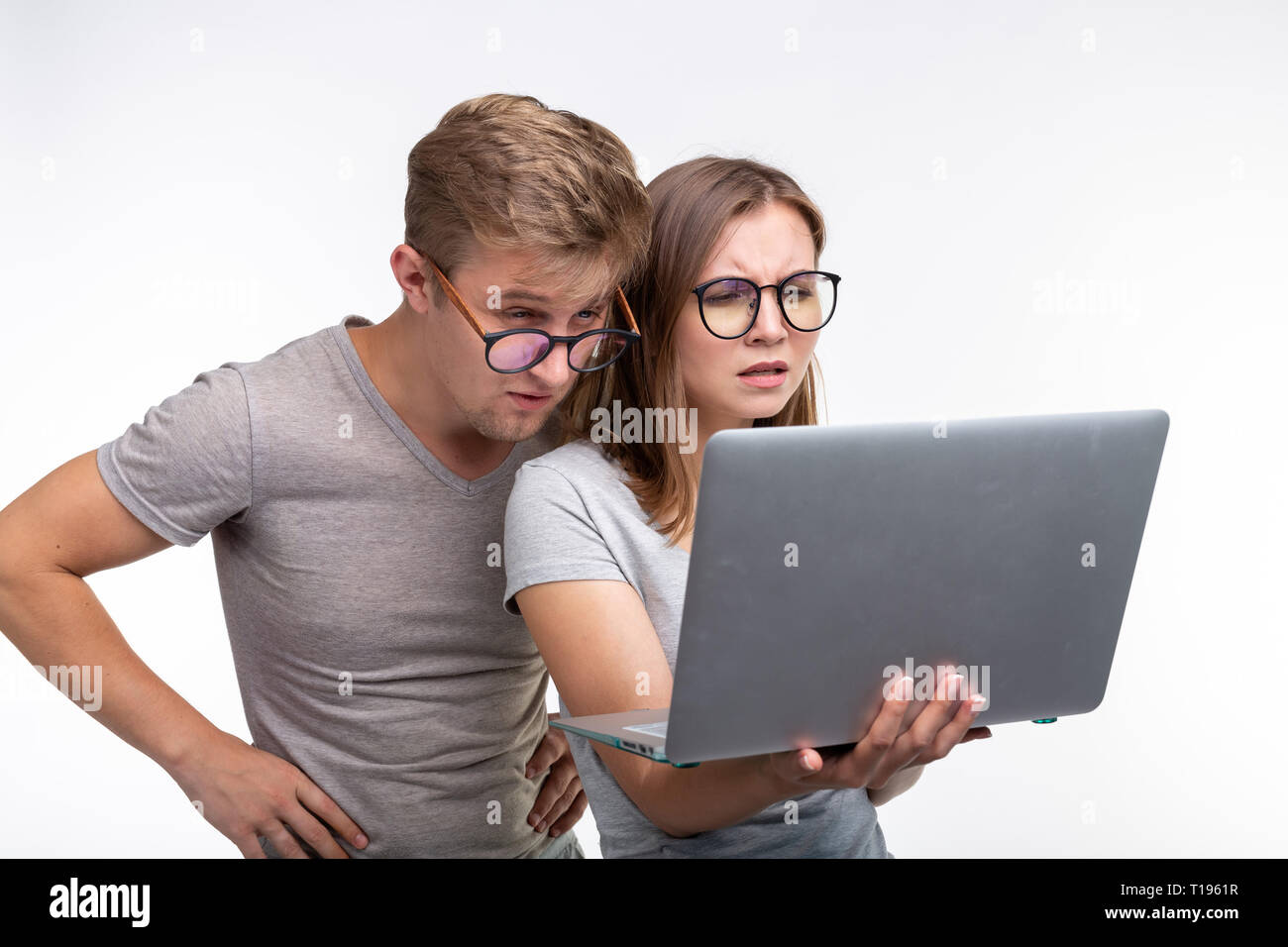 Nerds, study, people concept - a couple of students look at the netbook ...