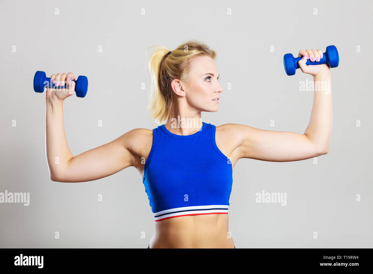 Sporty woman lifting light dumbbells weights. Fit girl exercising ...