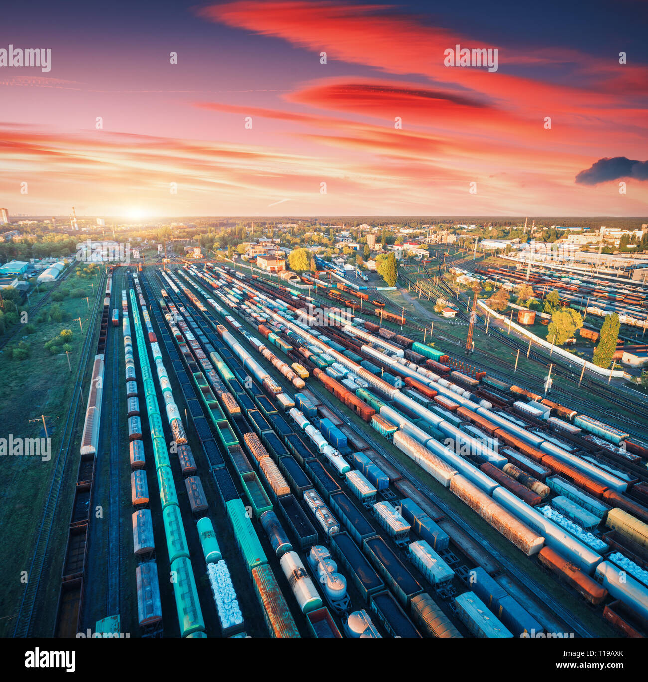Aerial view of freight trains on railway station at colorful sunset ...