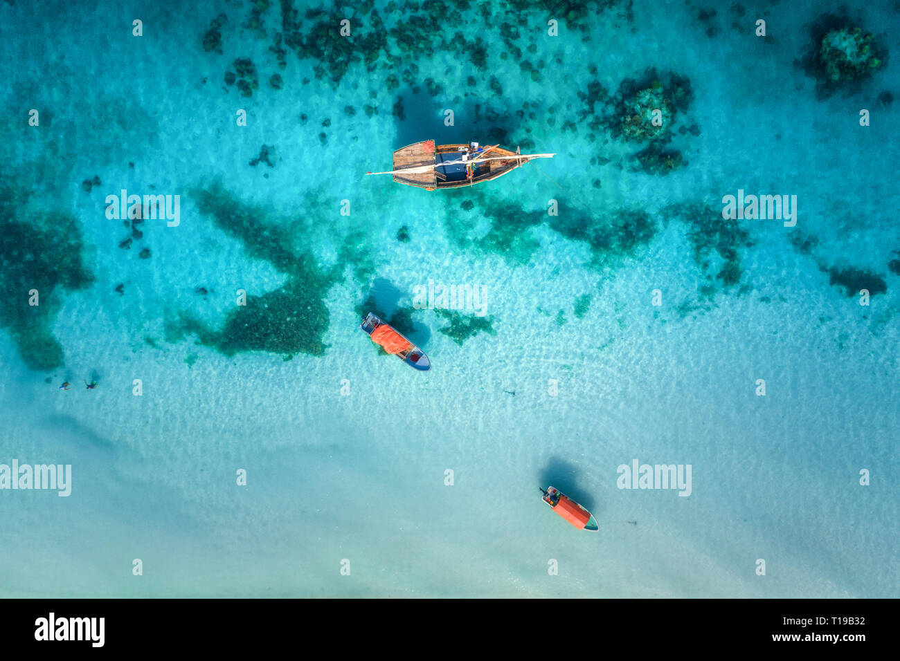 Aerial view of the fishing boats in clear blue water at sunny day in ...