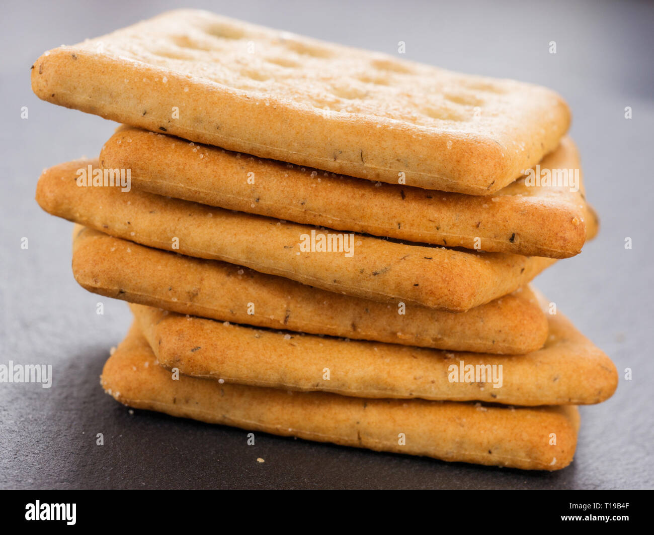 stack of square crackers on slate gray background. Dry salt cracker ...