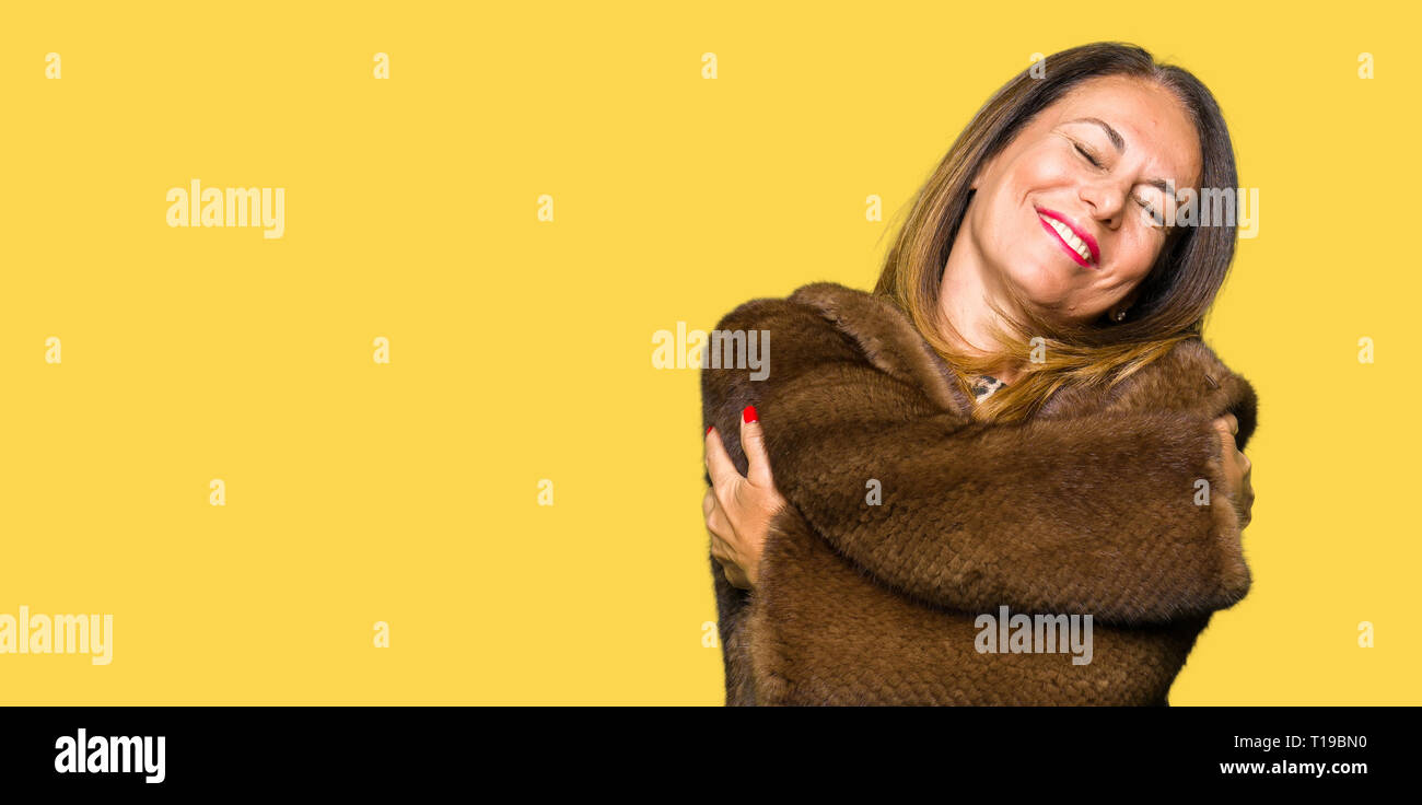 Beautiful middle age elegant woman wearing mink coat Hugging oneself ...
