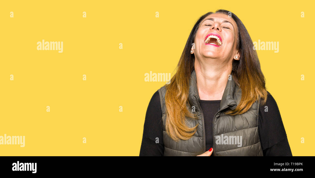 Beautiful middle age woman wearing winter vest Smiling and laughing ...