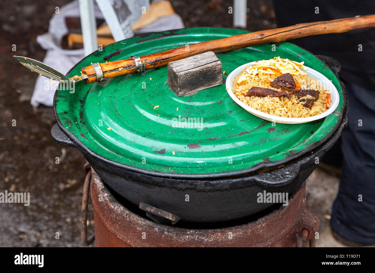 Cooking traditional Uzbek pilaf in a large cauldron outdoors Stock ...