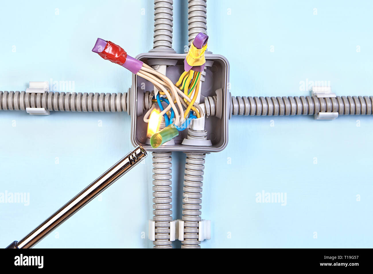 Electrician is heating insulation shrinkable tube put on ends of wires ...