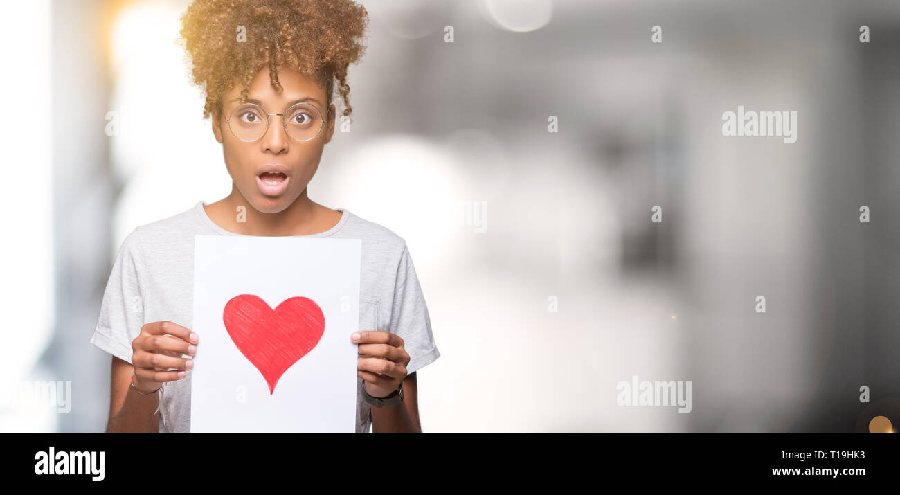 Young african american woman holding paper with red heart over isolated ...