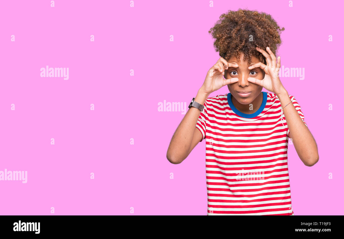 Beautiful young african american woman over isolated background Trying ...