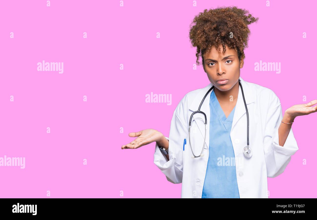 Young african american doctor woman over isolated background clueless ...