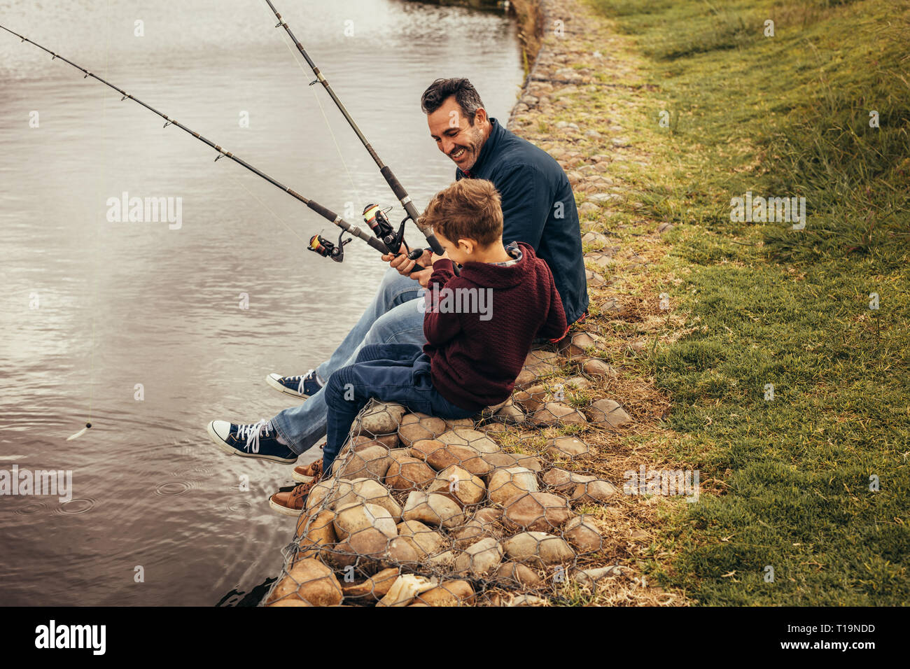 Man and boy fishing in a lake hi-res stock photography and images - Alamy