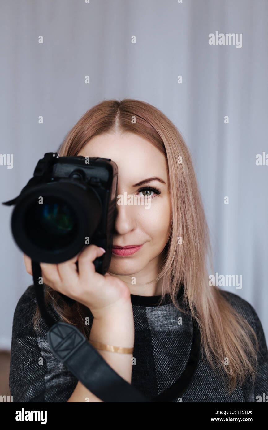 Portrait of a photographer covering her face with the camera Stock ...