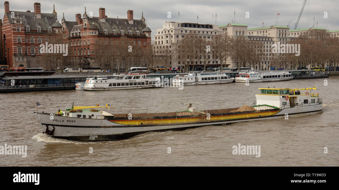 Self-propelled boat transports sand up the river Thames, passing near ...