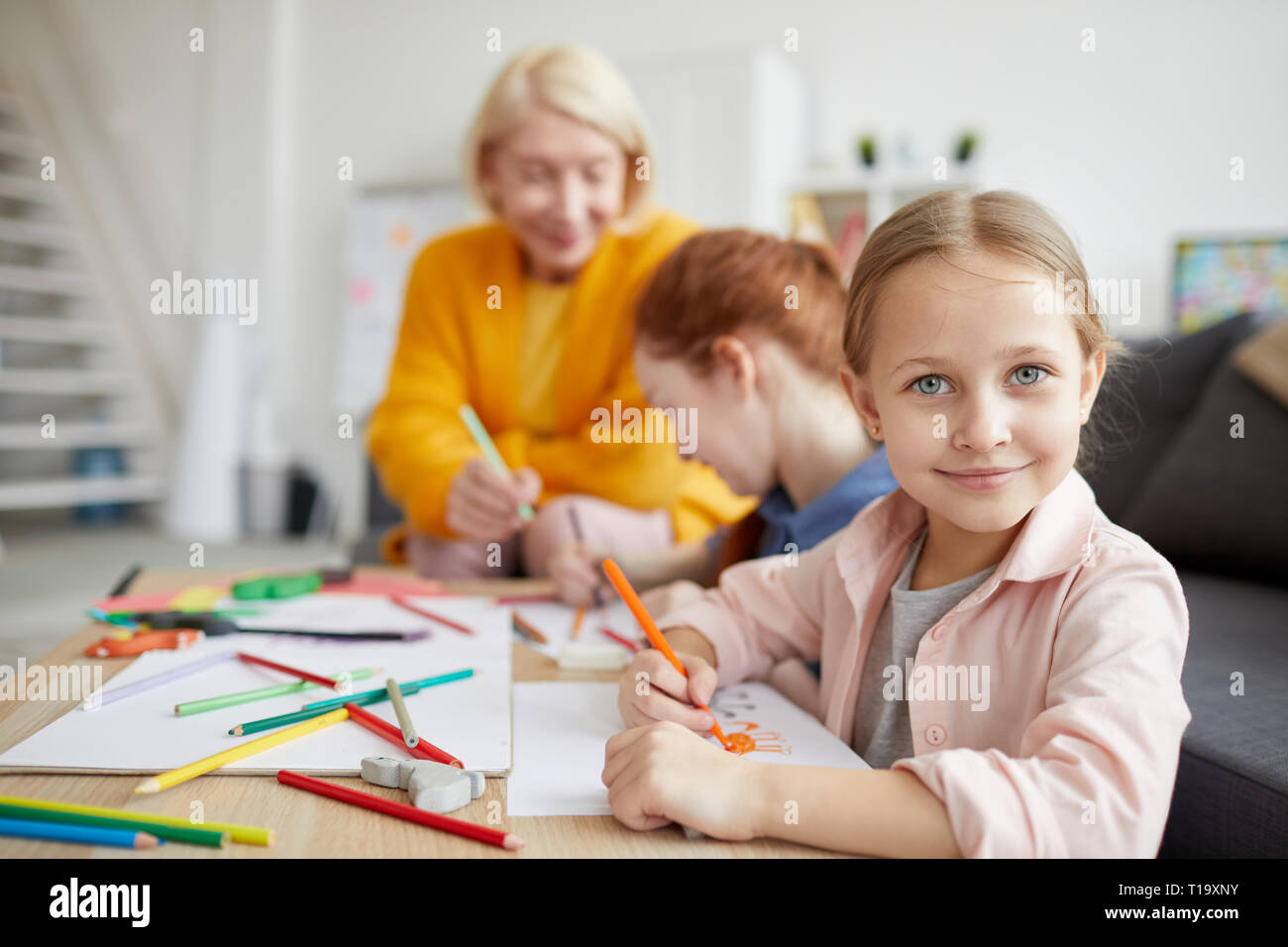 Cute Girl Looking at Camera while Drawing Stock Photo - Alamy