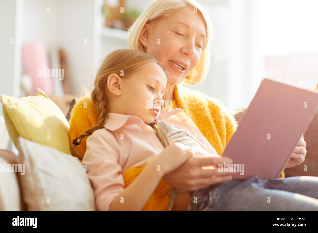 Mother Reading Stories in Sunlight Stock Photo - Alamy