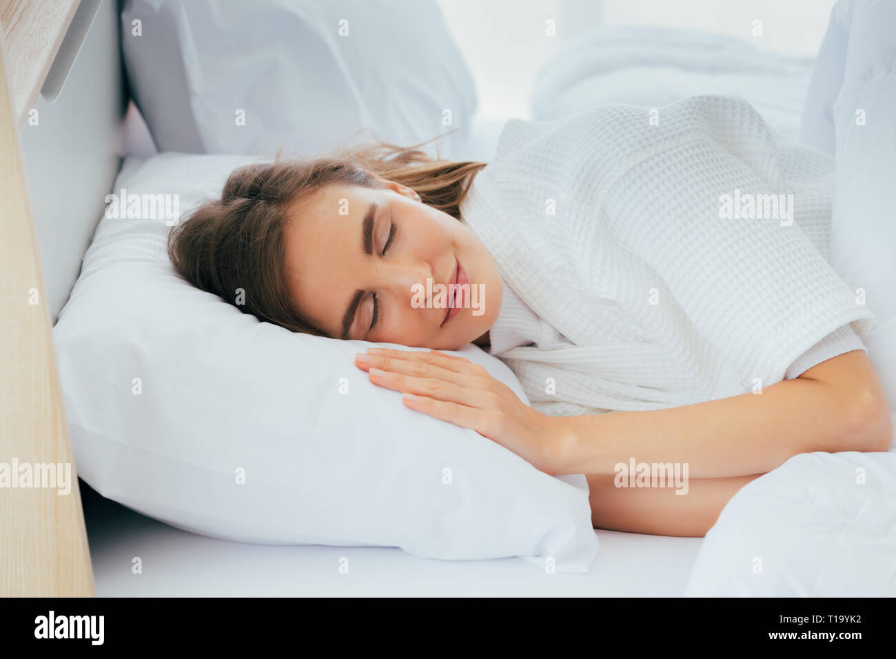 Young happy woman with closed eyes sleeping on bed with calm and ...