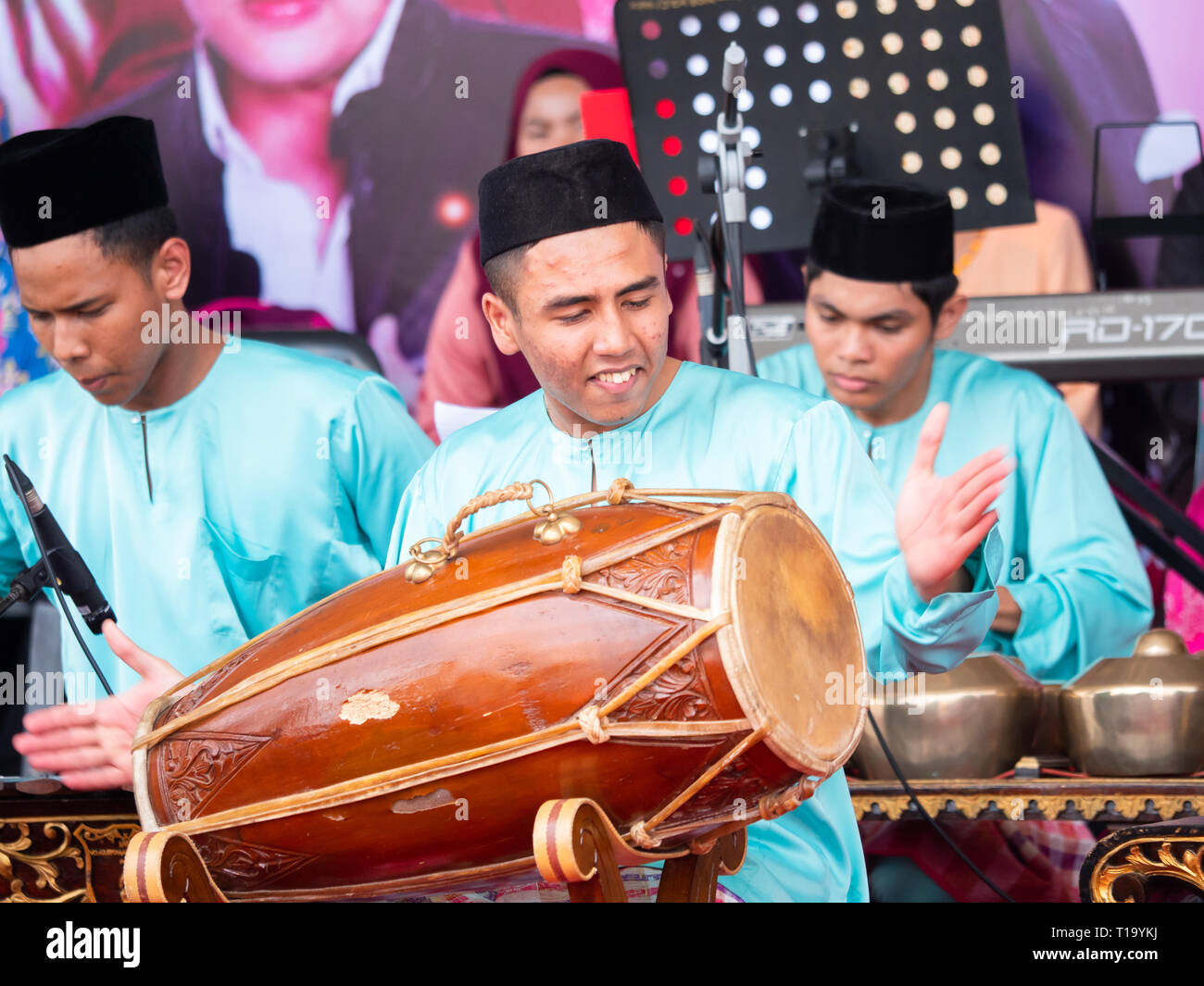 Malaysian orchestra playing traditional instruments and wearing ...