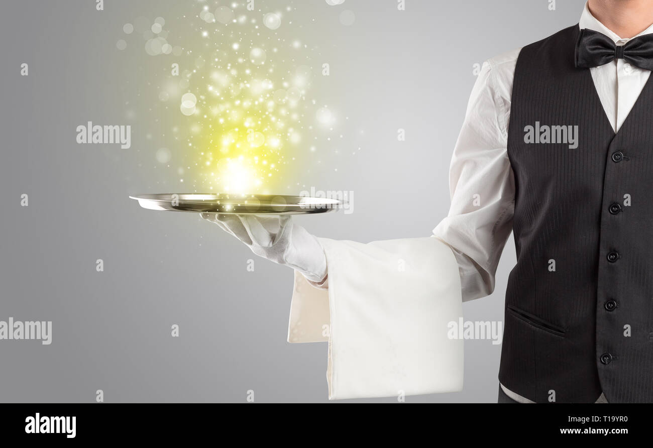 Elegant young waiter serving mysterious light on tray Stock Photo - Alamy