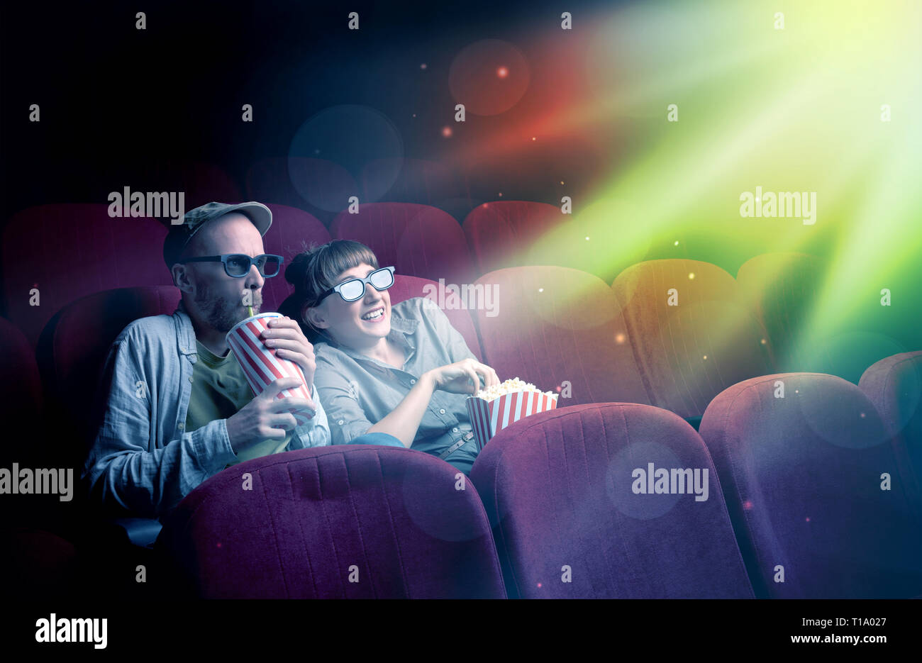 Teenager couple cuddling and watching the climax part of the movie ...