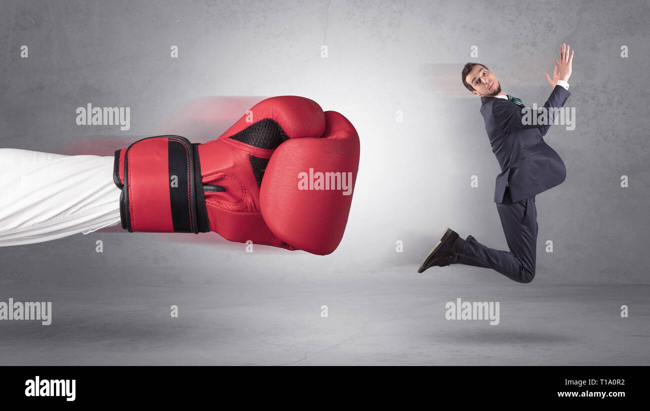 Businessman gets a hit from a giant hand with boxing gloves Stock Photo ...