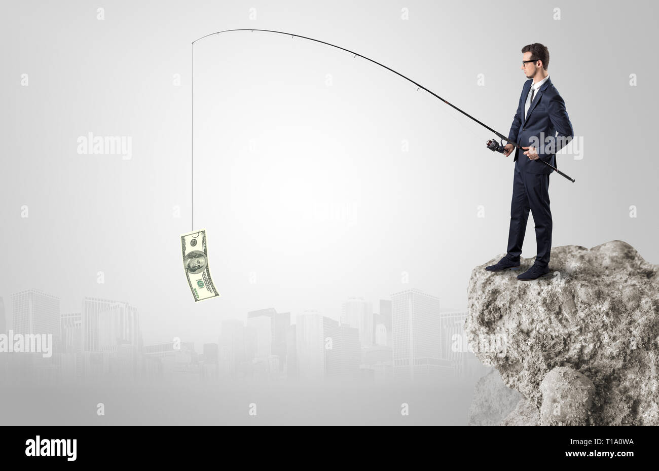 Elegant young businessman fishing cash from a huge rock Stock Photo - Alamy