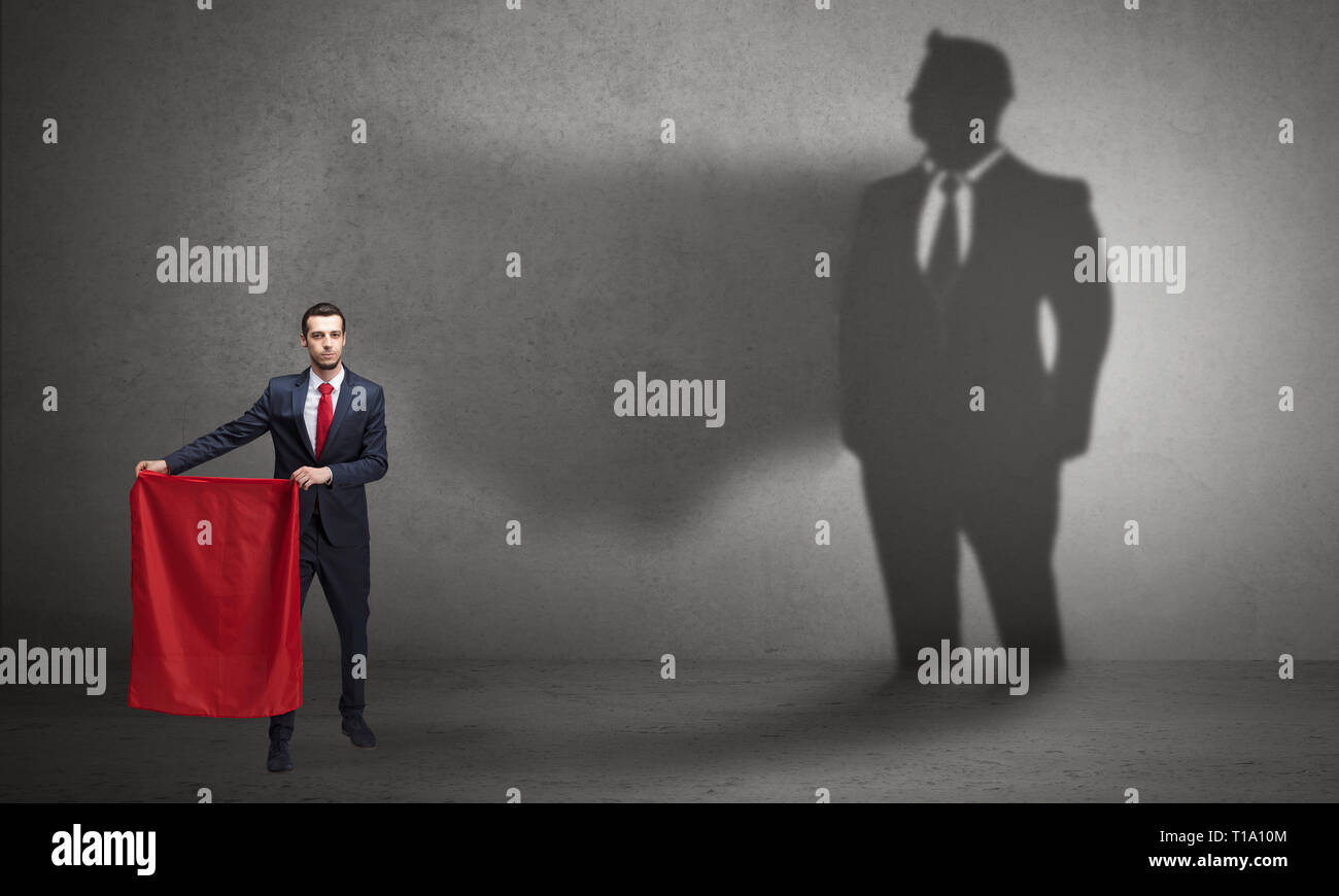 Businessman standing with red cloth on his hand and his shadow on the ...