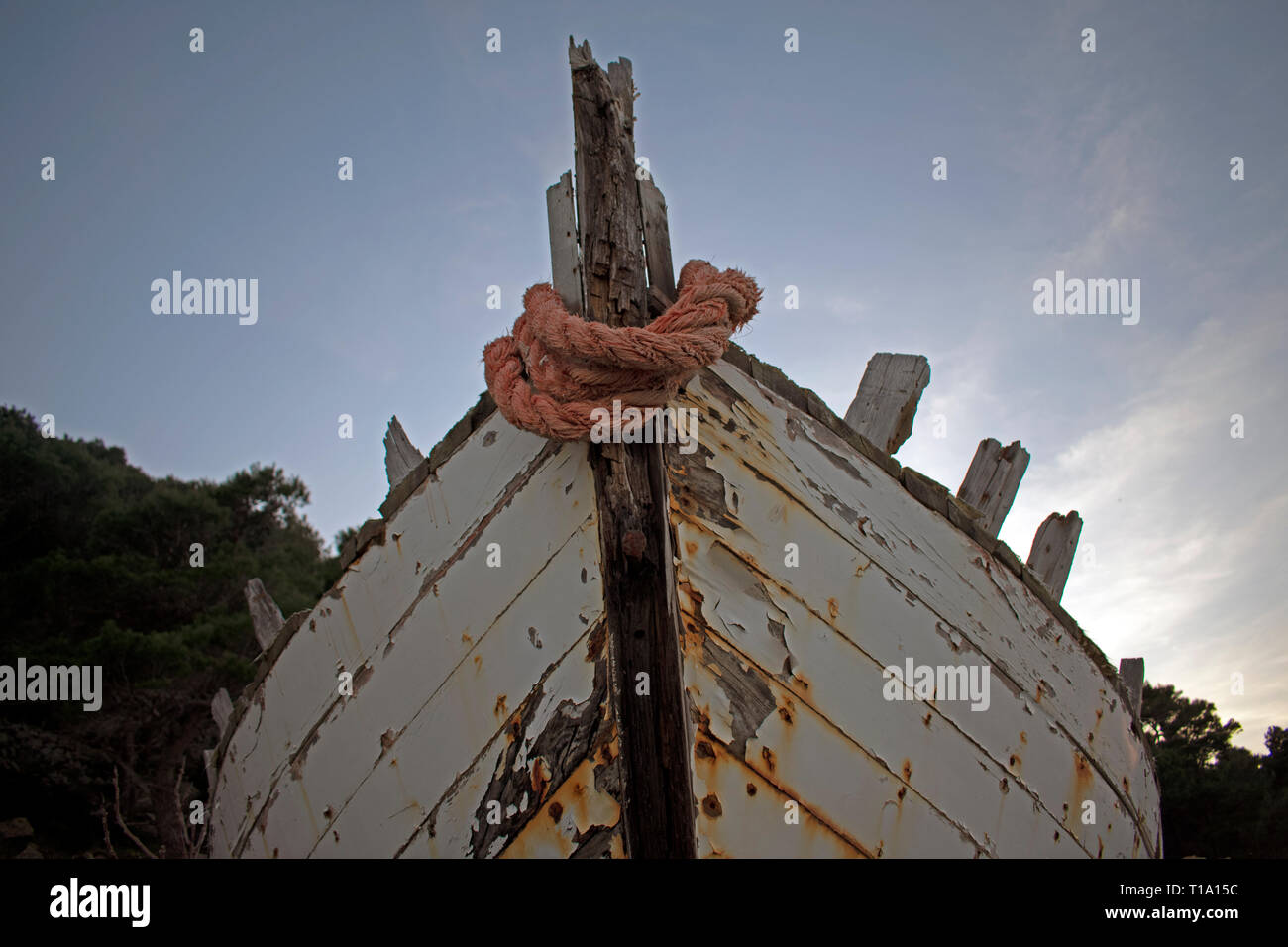 Old rotten wooden ship with paint peeling off and rope wrapped around ...