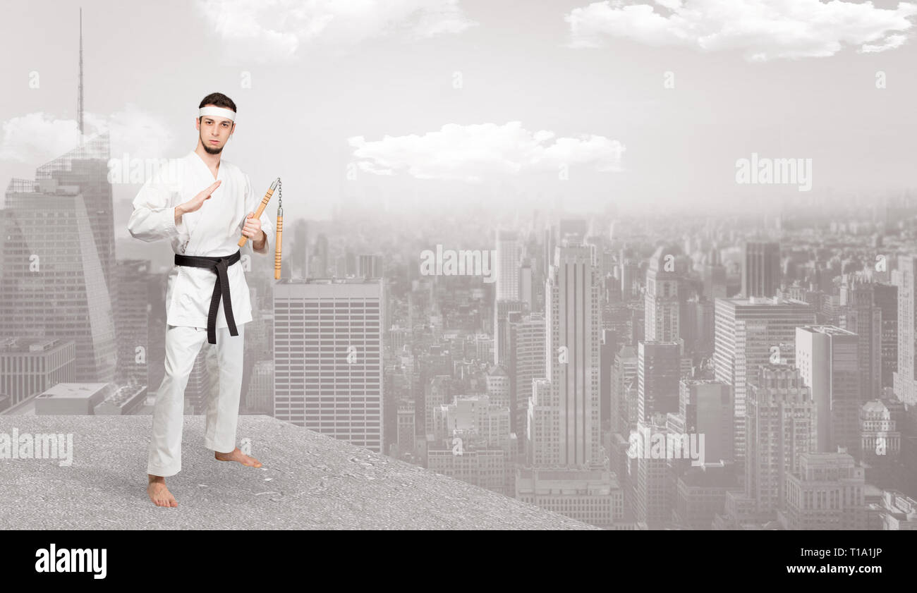 Young karate trainer doing karate tricks on the top of a metropolitan ...