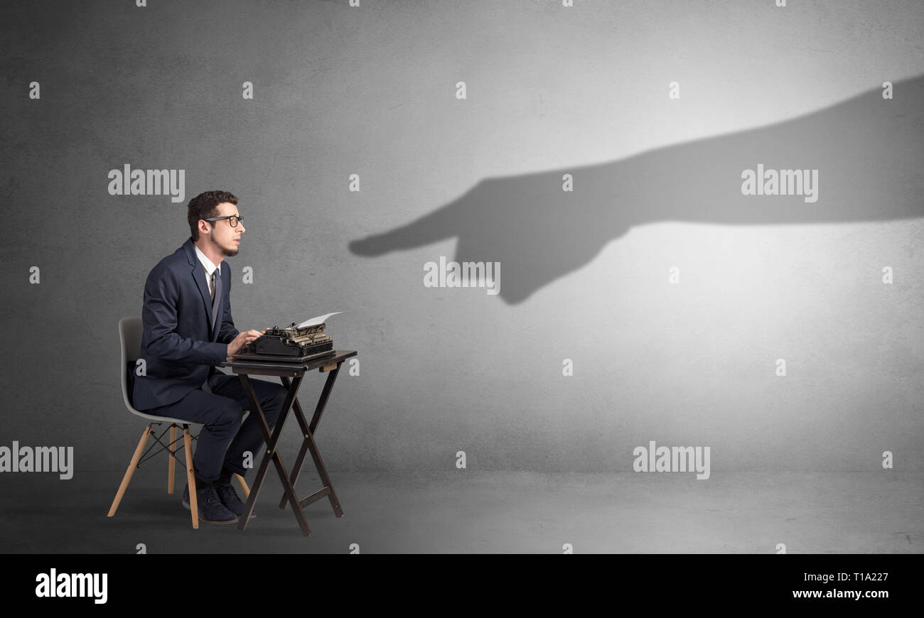 Shadow hand pointing at a small afraid worker Stock Photo - Alamy