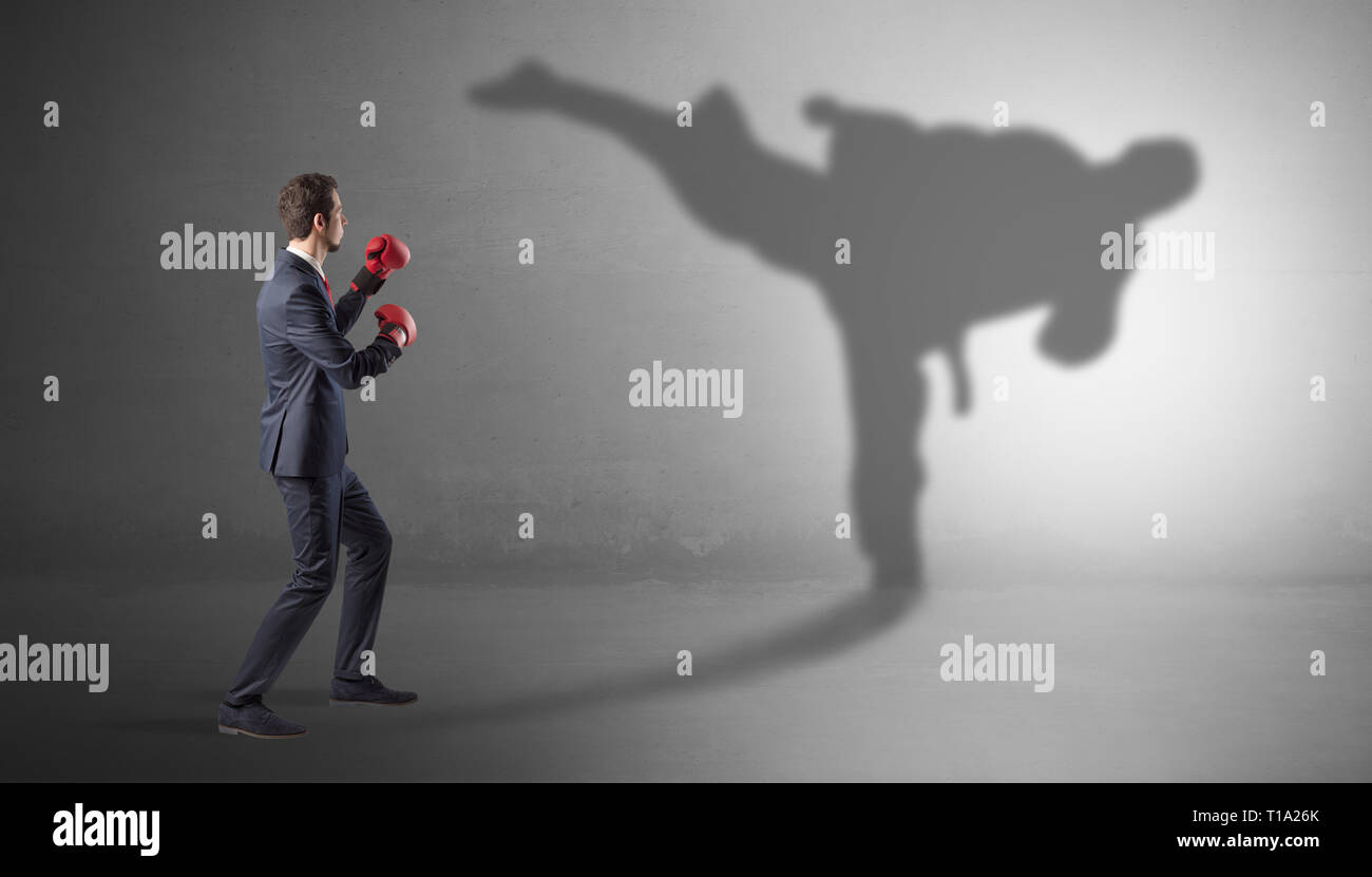 Businessman fighting with his strong karate man shadow Stock Photo - Alamy