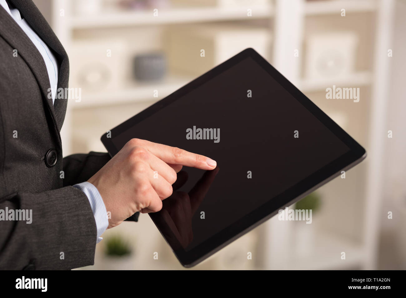 Business woman below chest using tablet in a homey environment Stock ...