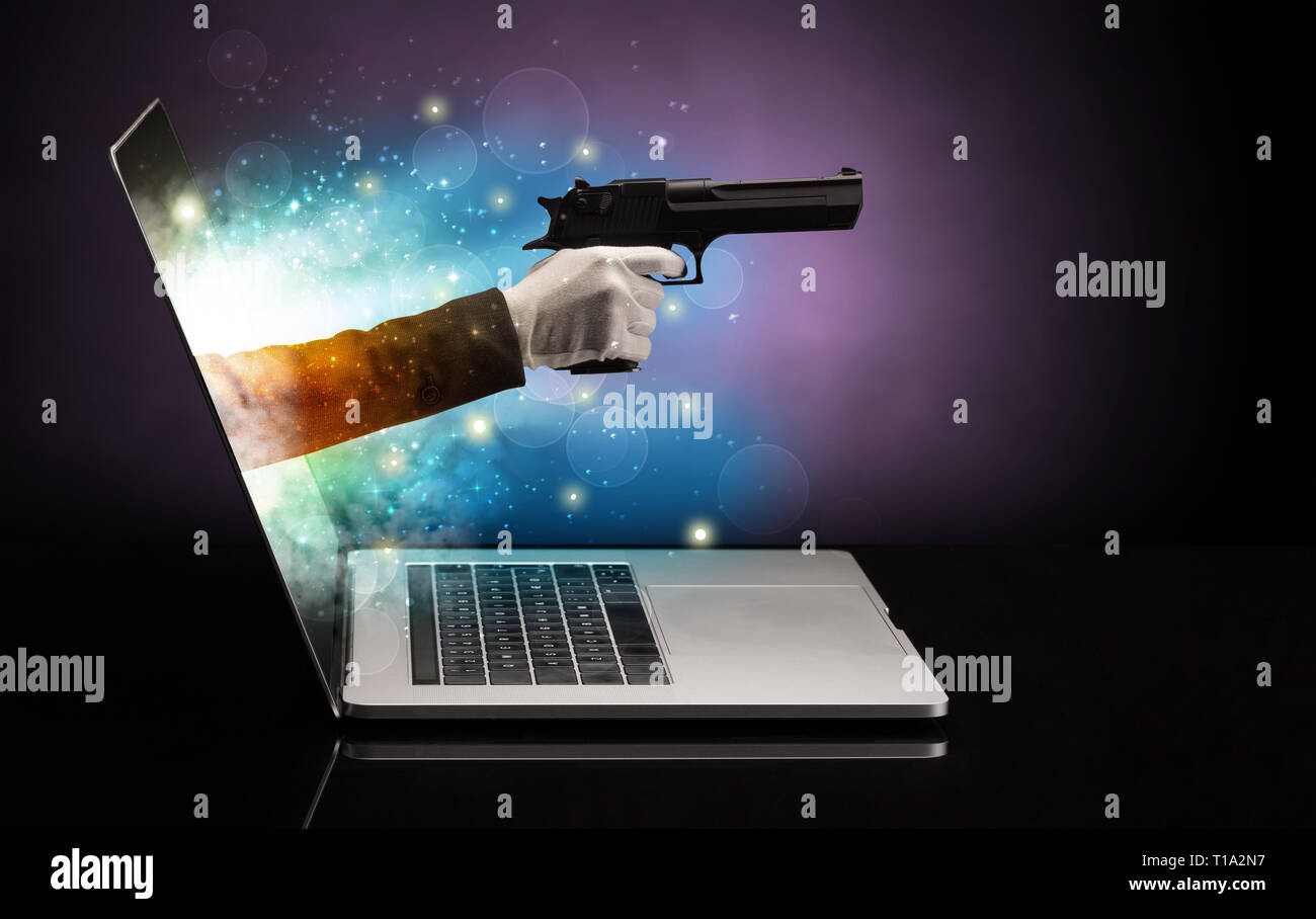 Hand with gun coming out of a laptop with sparkling effects Stock Photo ...