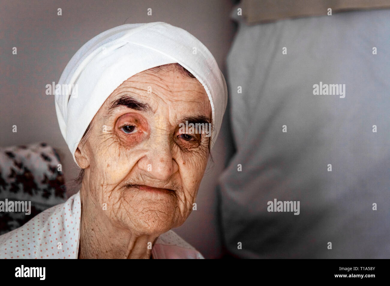 Portrait of an elderly Turkish woman with traditional bonnet sitting in ...