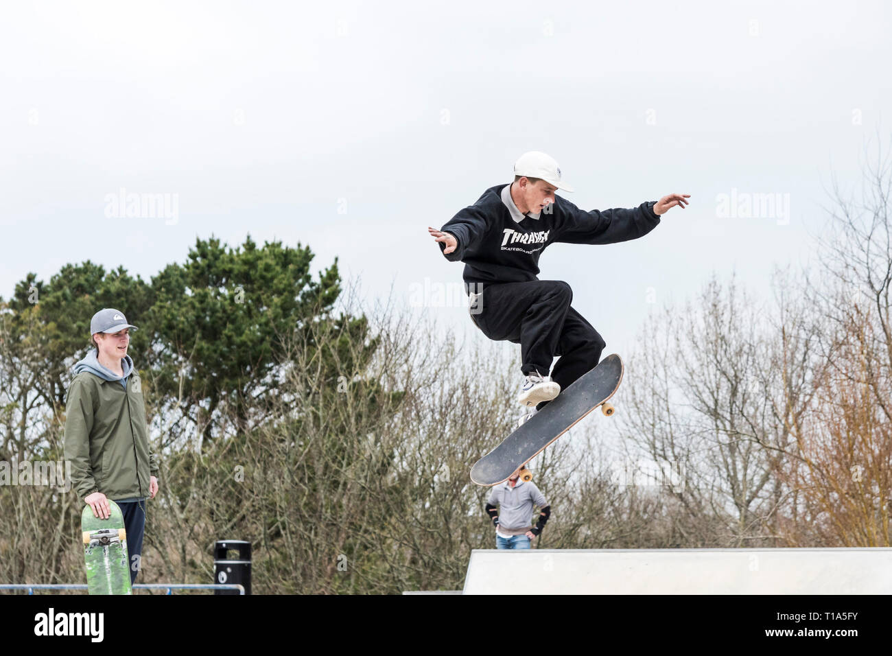 A skateboarder watching another skateboarder performing an aerial trick ...