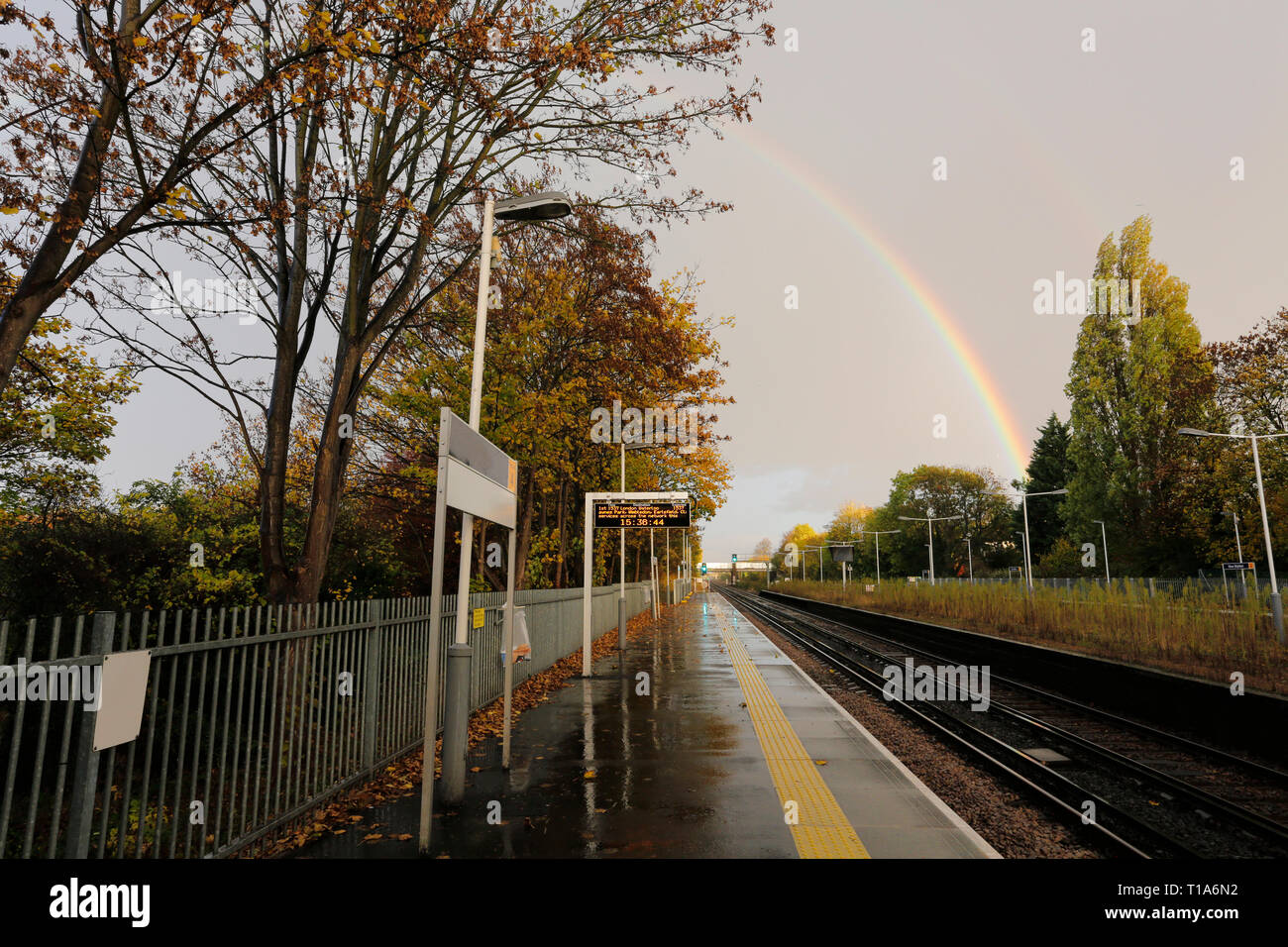 Suburban railway station, rainbow in background Stock Photo - Alamy