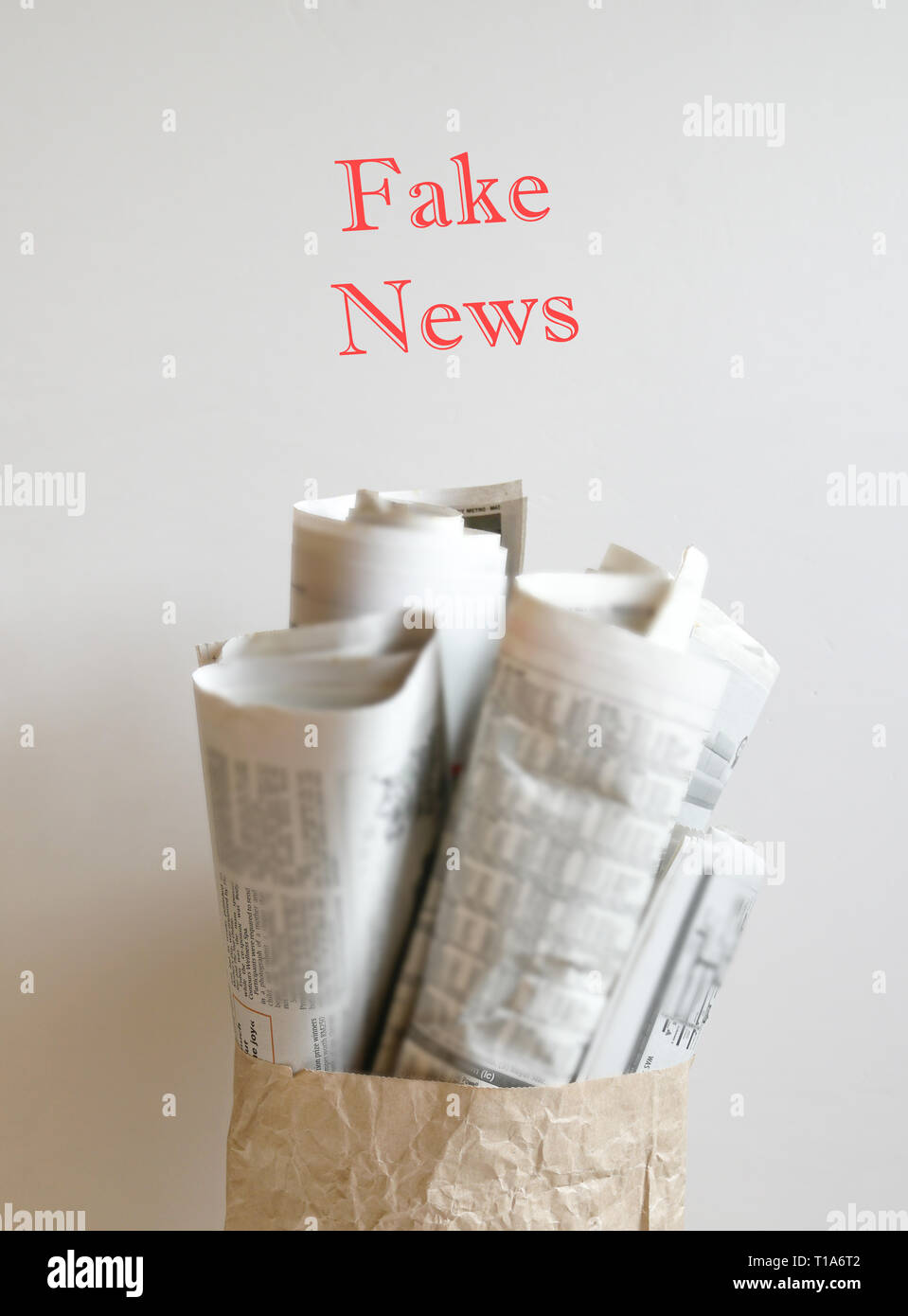 Fake news concept - red words "Fake News" on top of paper bag filled ...