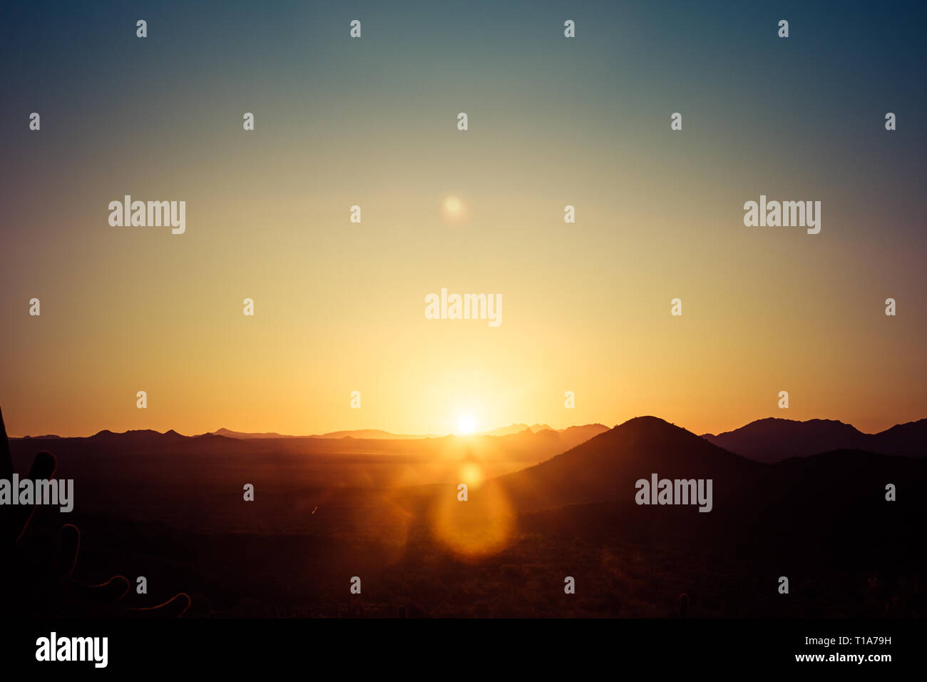 The sun rising above the Arizona Desert with the Four Peaks in the ...