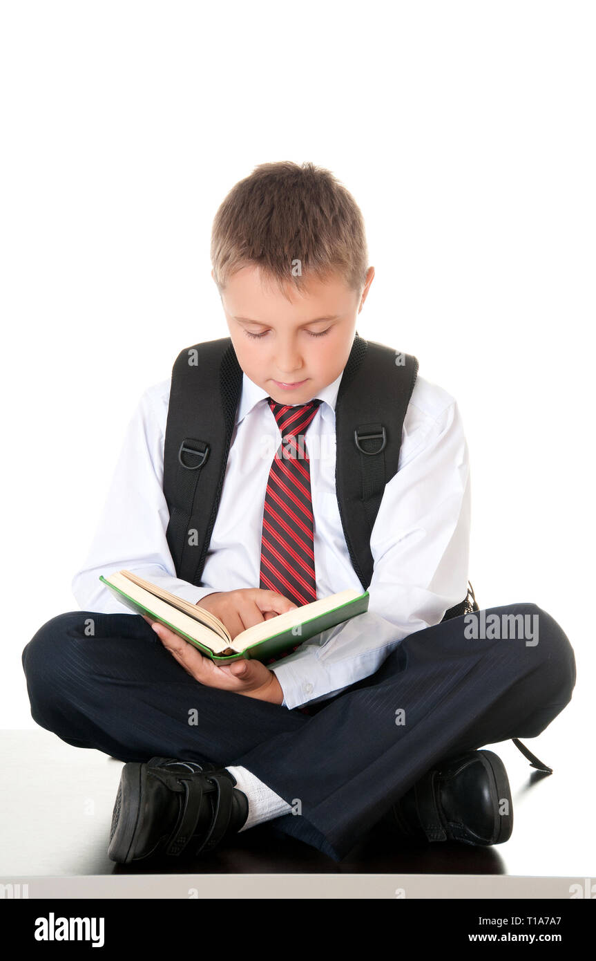 A diligent boy reads a book and prepares for exams and tests. Schoolboy ...