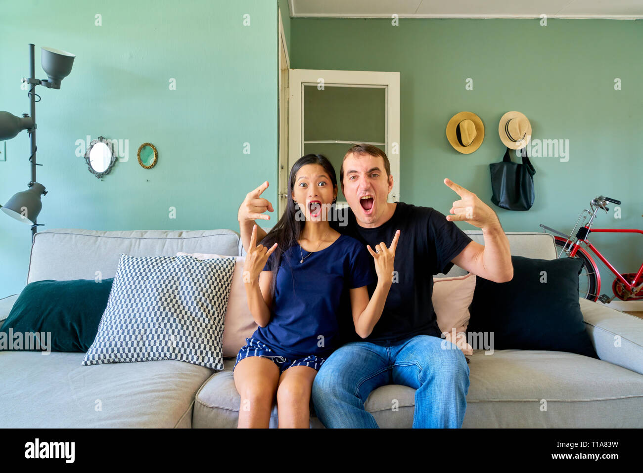 Couple screaming and showing rock sign. Funky faces Stock Photo - Alamy